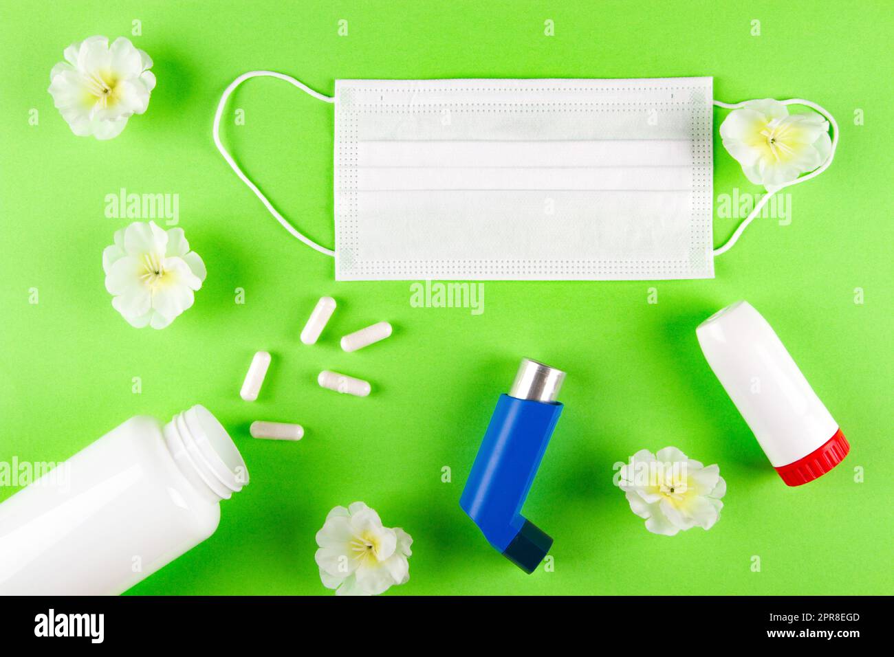 White shurgary mask, white flowers, bottle with pills and inhalers on ...