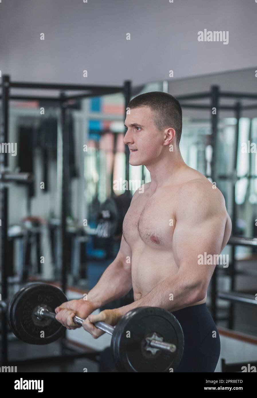 athlete lifts barbell training biceps with all might Stock Photo - Alamy