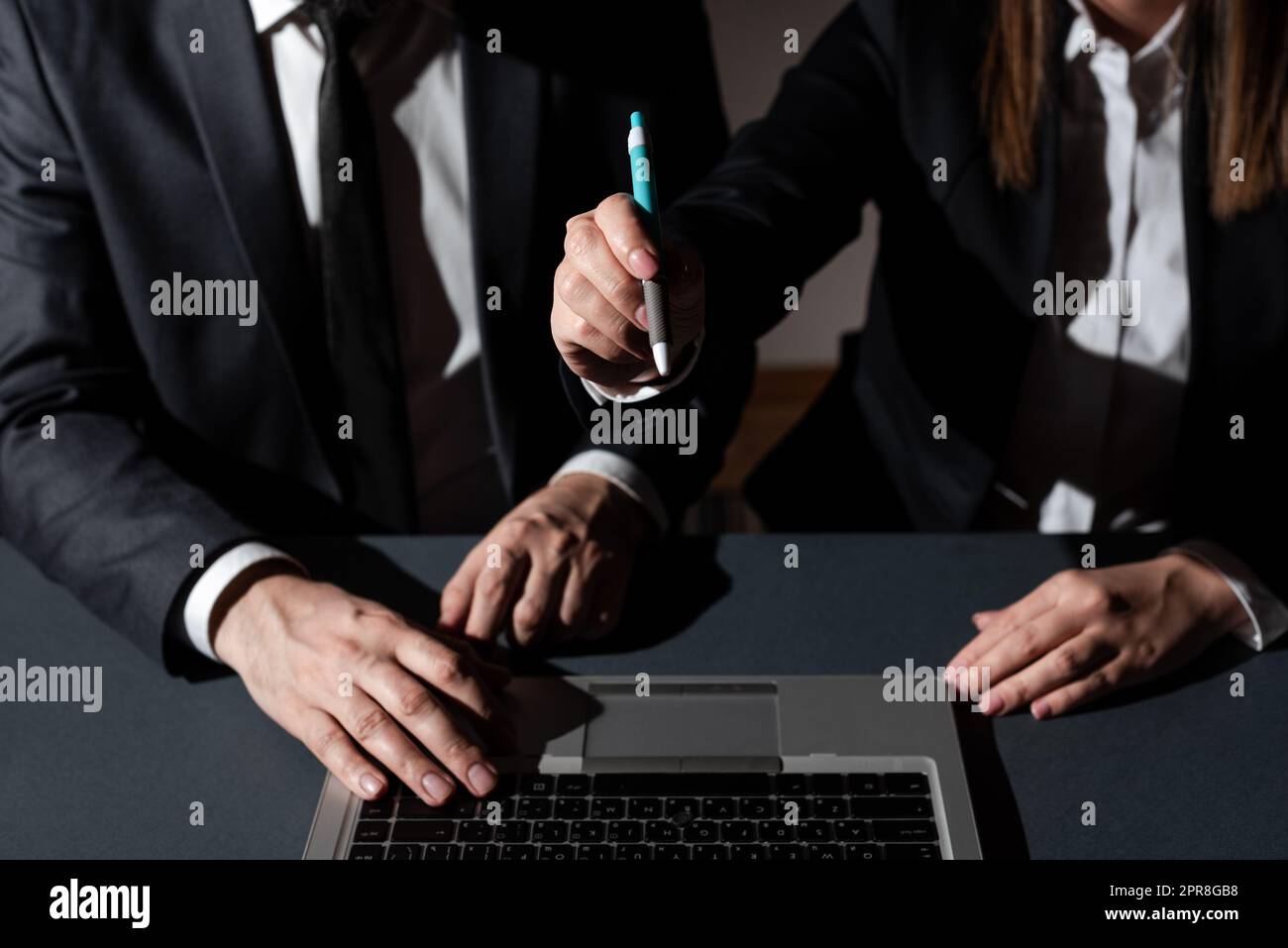 Man Typing On Lap Top And Woman Pointing With Pen On Important Message ...