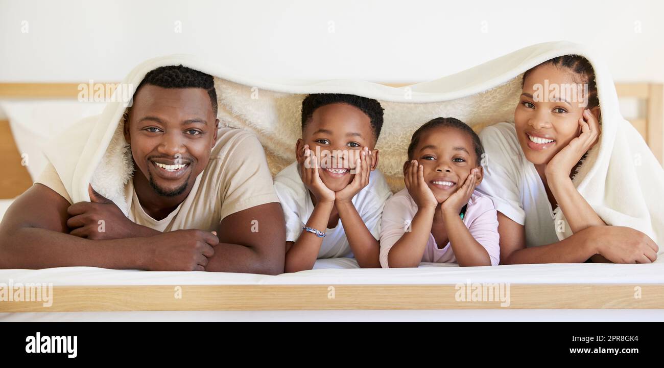 a beautiful young family bonding in bed together Stock Photo - Alamy