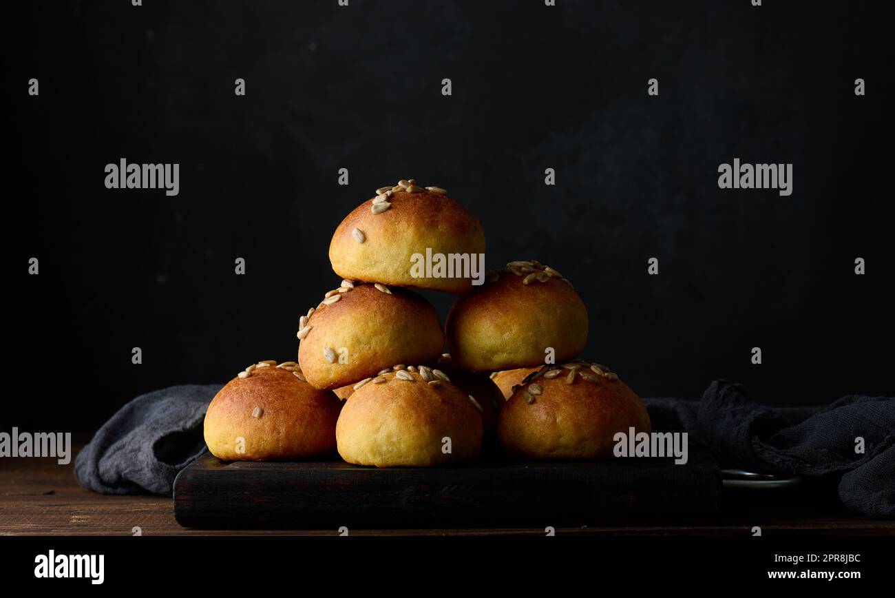 Baked round buns on a wooden table, black background Stock Photo - Alamy