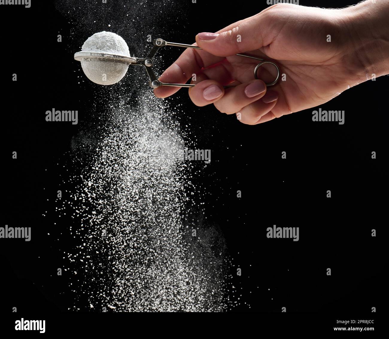 White sugar falling in black hi-res stock photography and images - Alamy