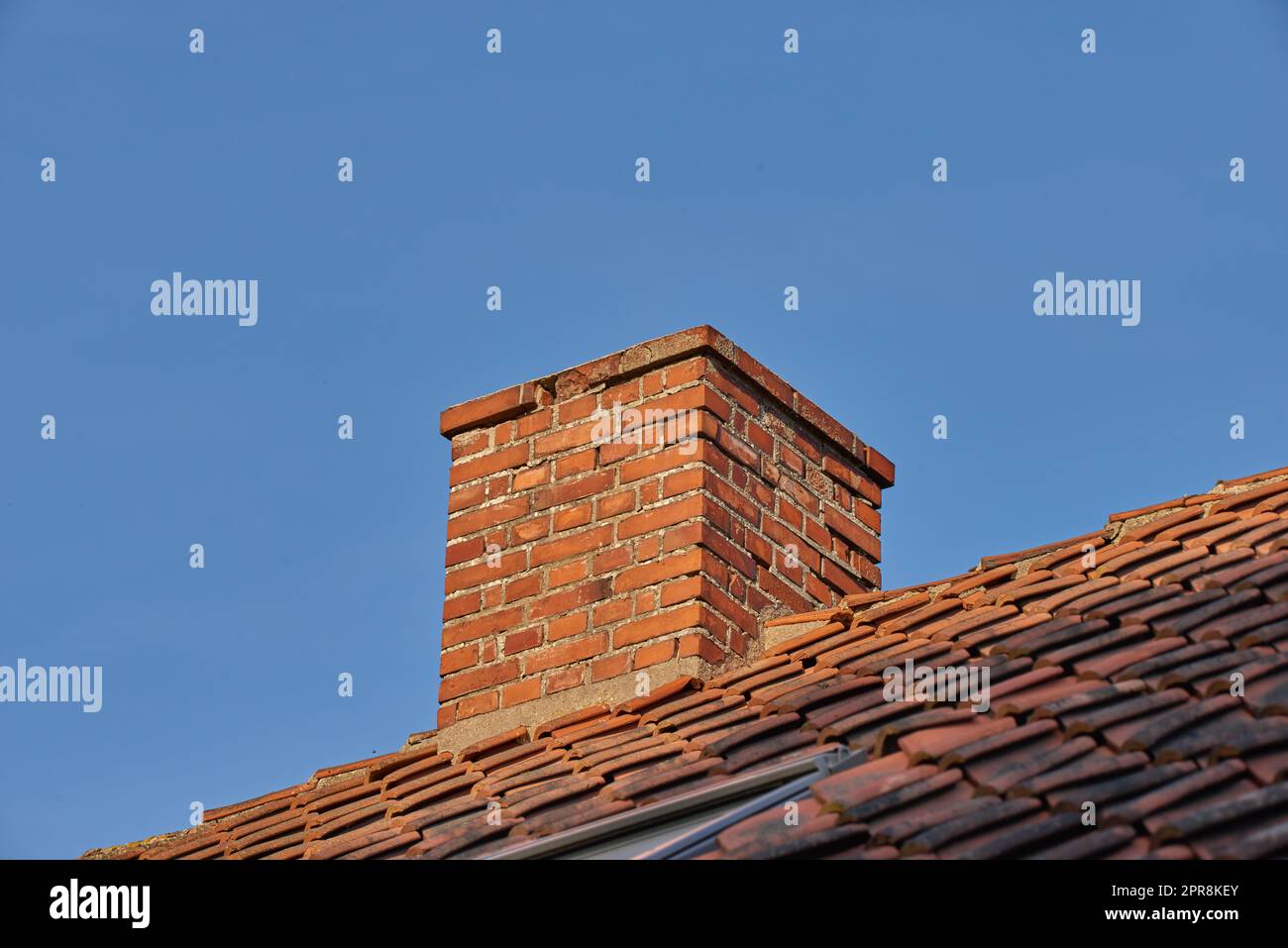 Copy space with a chimney on the rooftop of a house or building against ...