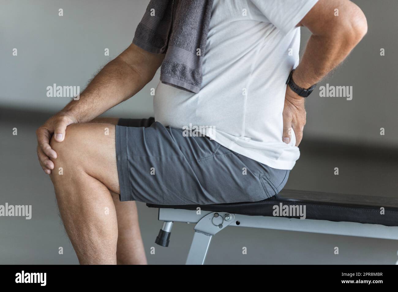 Active senior in gym with back pain Stock Photo - Alamy