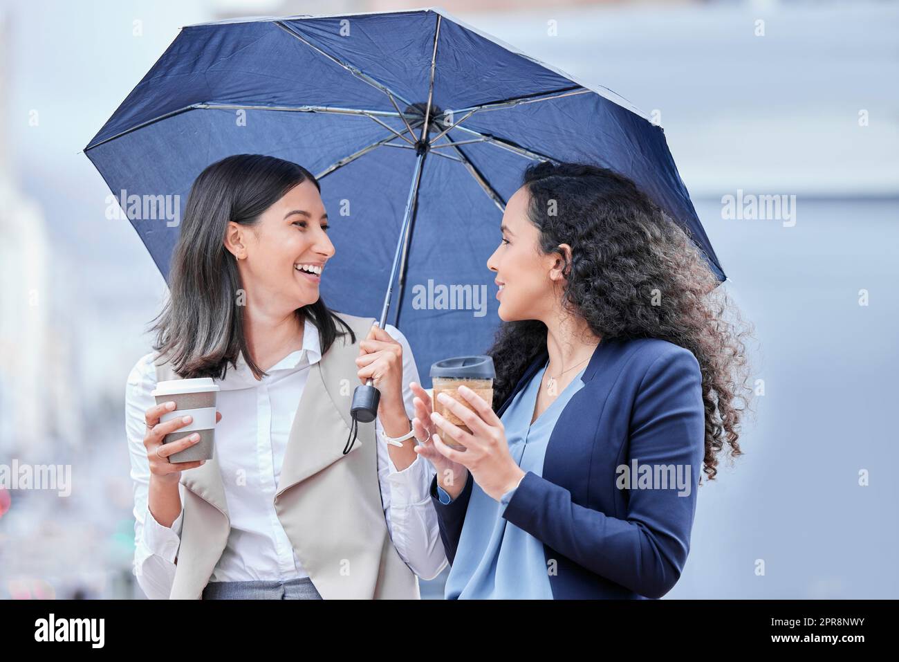 Two People Standing Under An Umbrella In The Rain