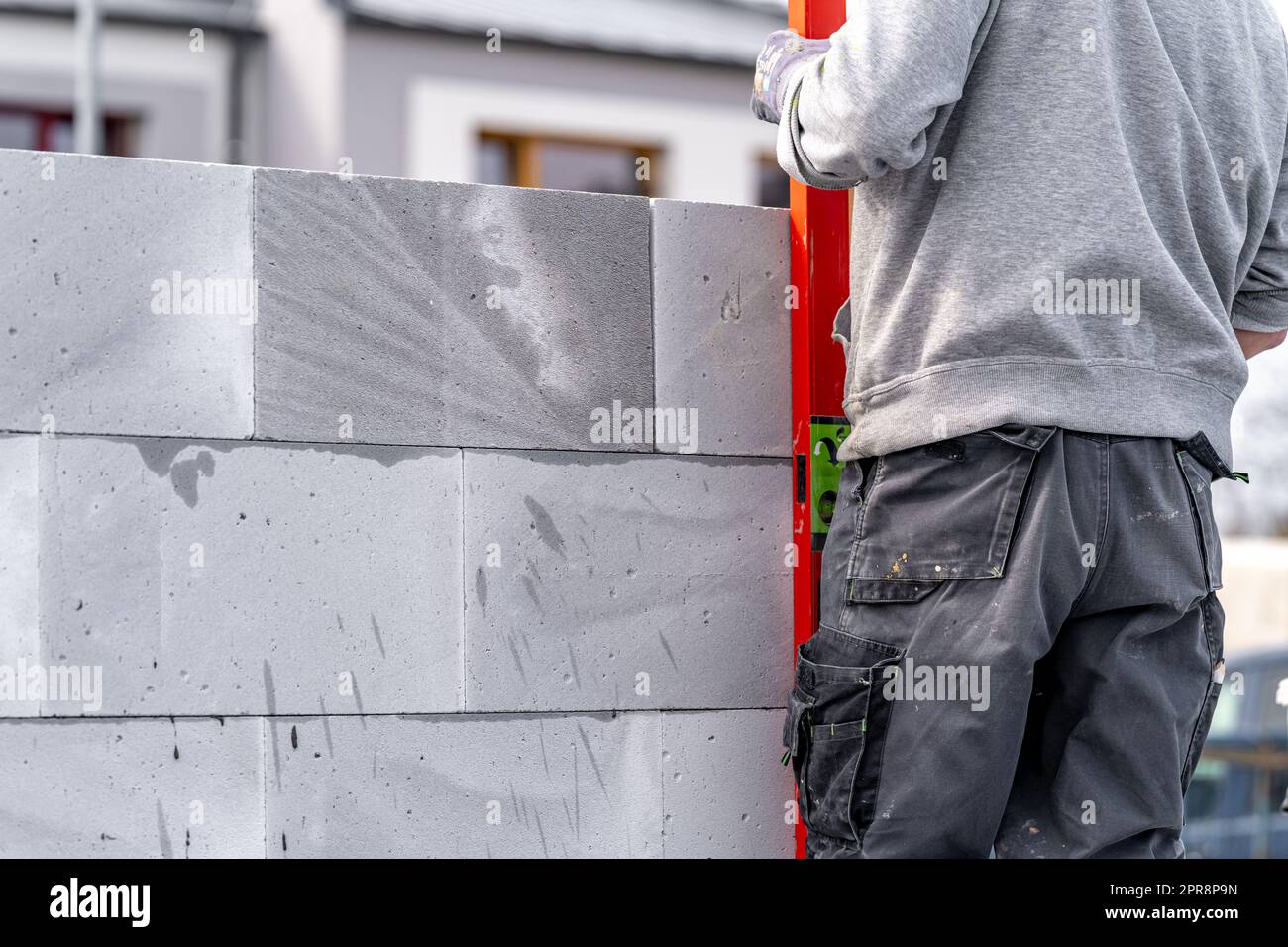 bricklayer leveling bricks with the help of a spirit level during the ...