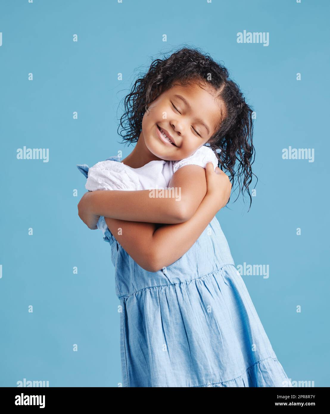 Adorable loveable little girl looking happy while hugging embracing ...