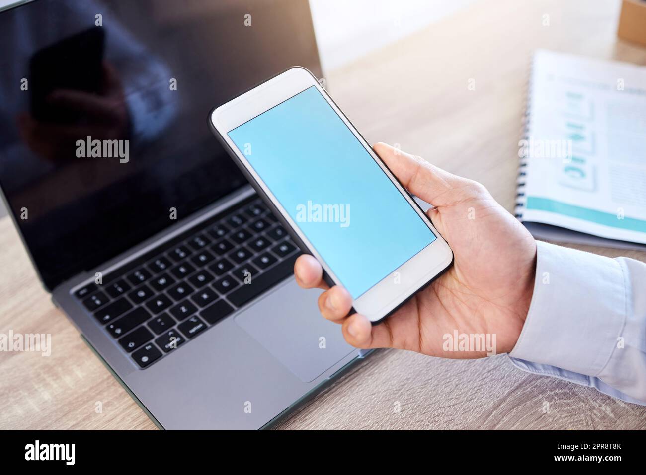 Closeup businessman browsing the internet on a cellphone in an office ...