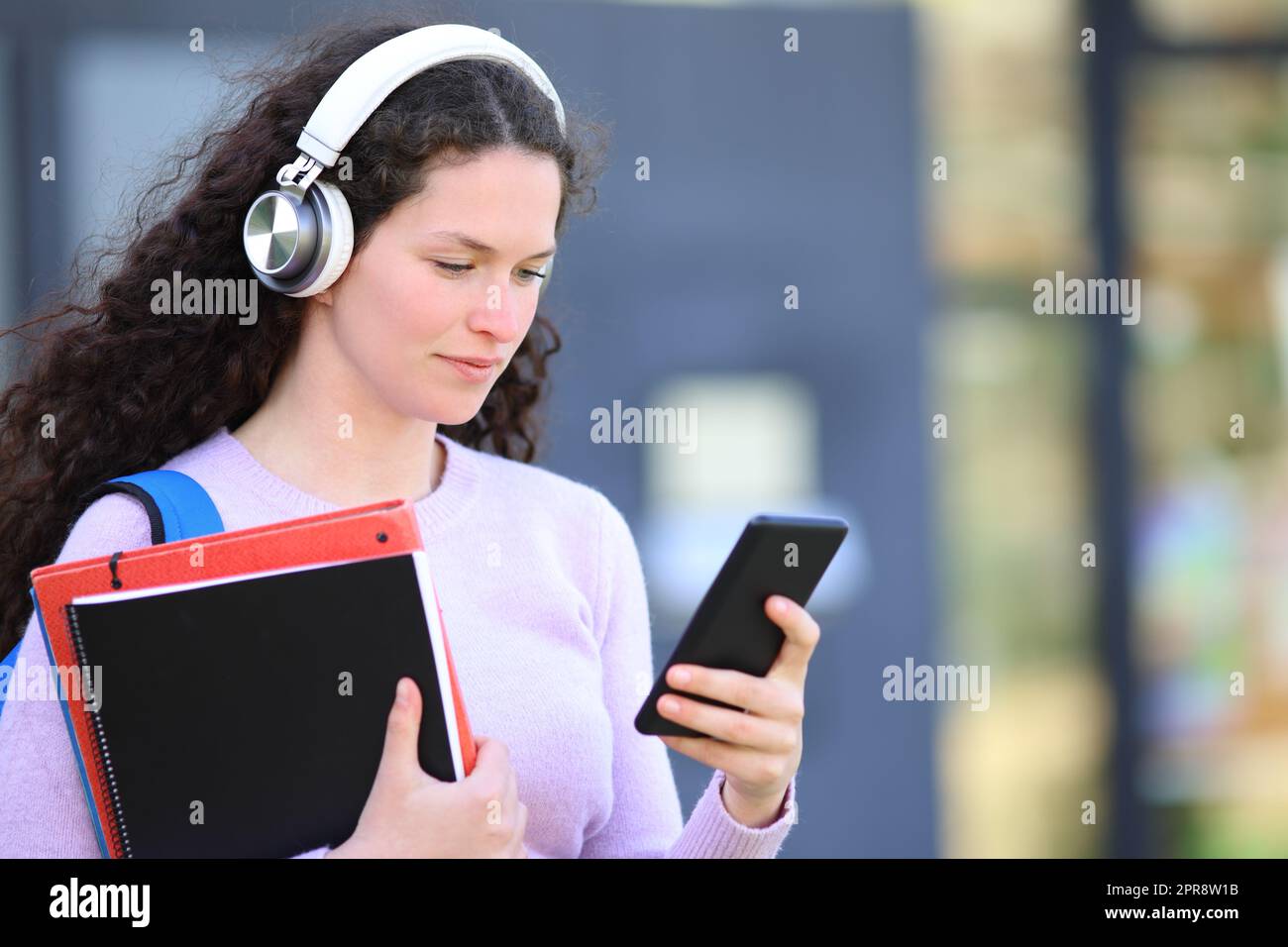 Serious student checking smart phone standing in a campus Stock Photo ...