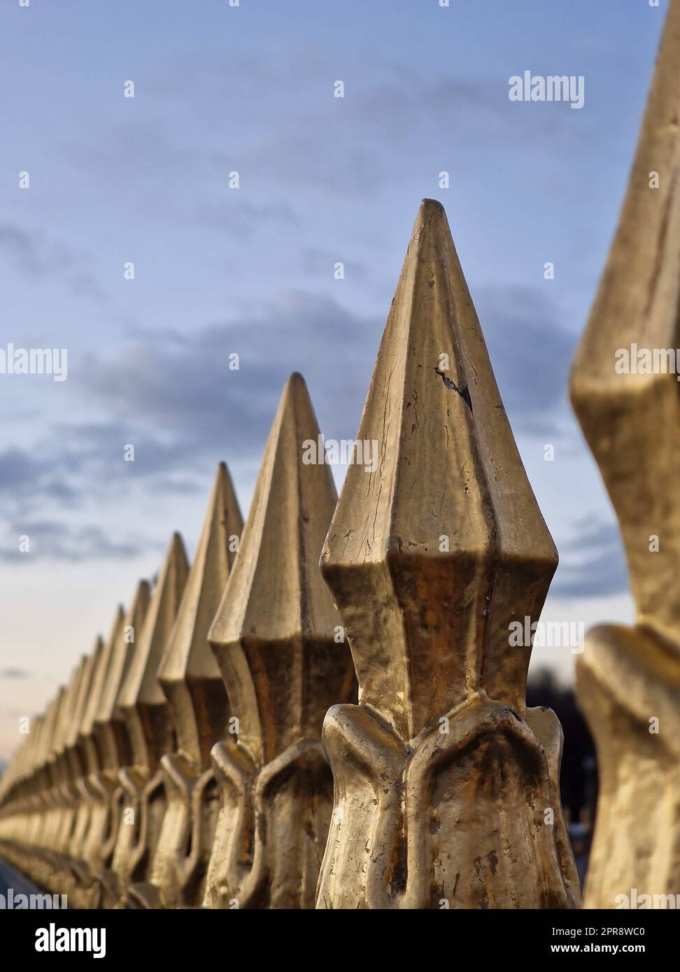 A vertical line up of golden fence tops Stock Photo - Alamy