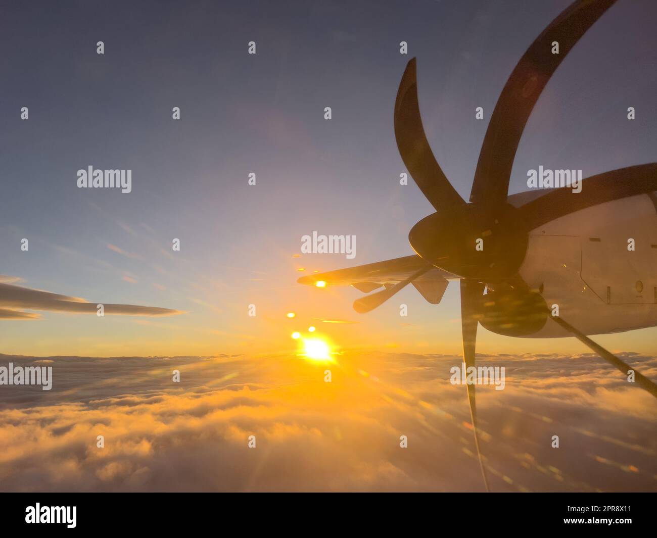 Rotating propeller of an airplane flying in the rays of the setting sun ...