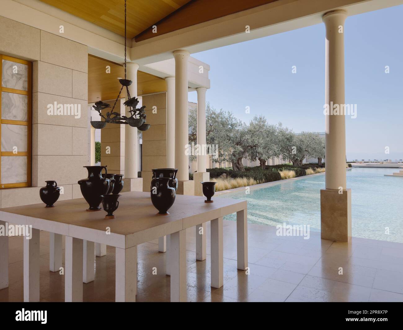 Table with amphoras stands on the terrace with columns by the pool ...