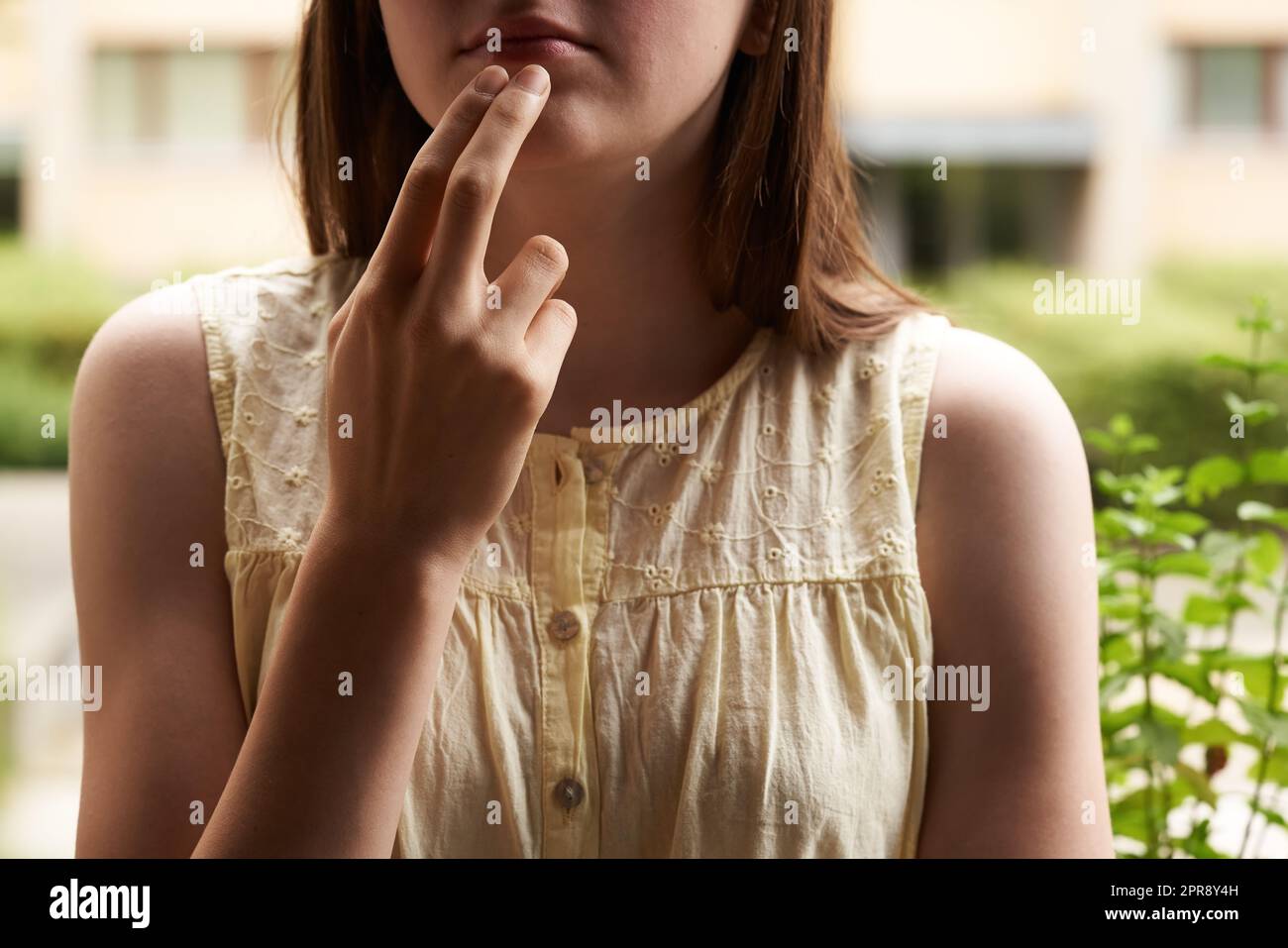 Hand of a teenage girl tapping on the chin point - practicing EFT or ...