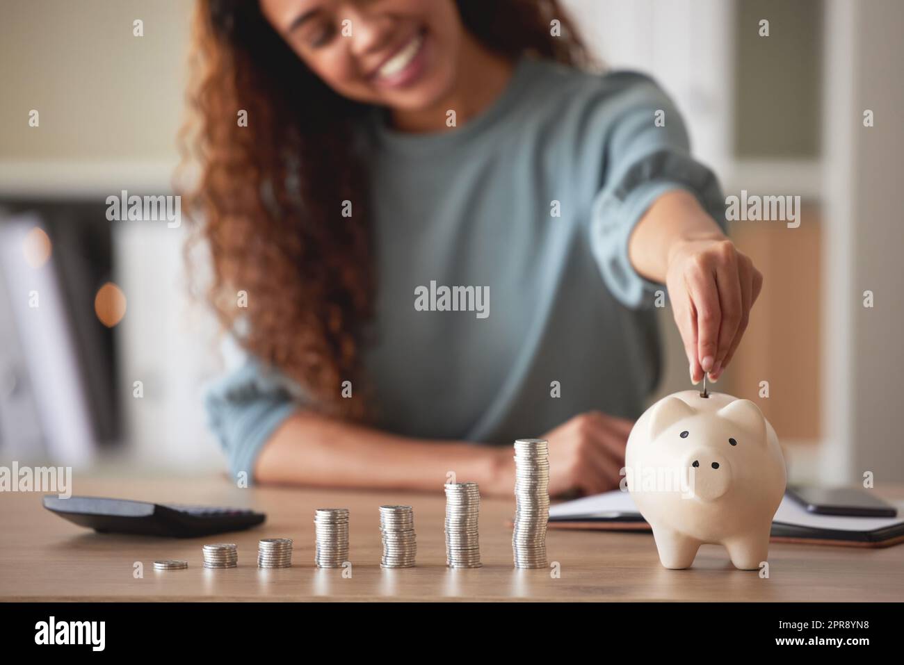 Young african american woman money putting coins into a piggybank at ...