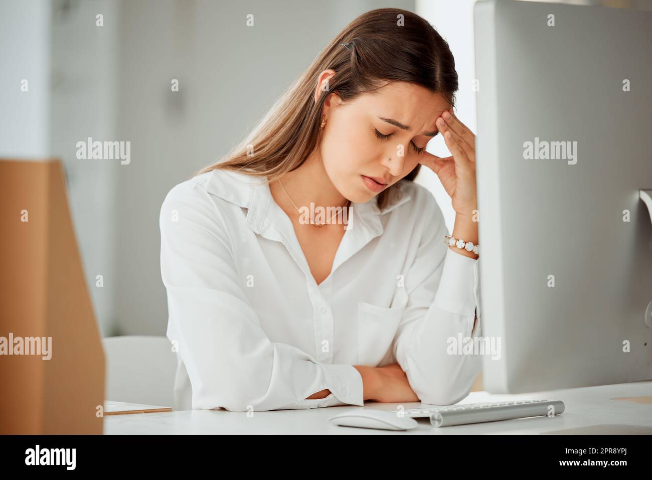 One anxious young hispanic business woman suffering with a headache ...