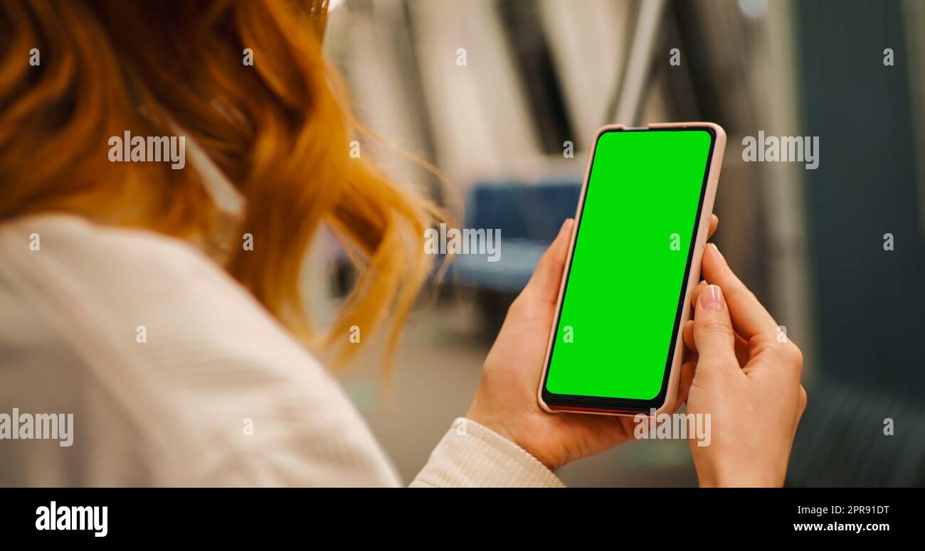 Over the sholder shot of woman watching green screen phone on the ...