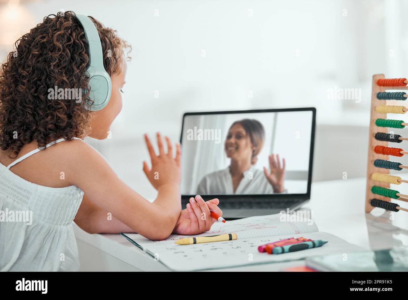 Learning from a distance. a little girl in a virtual class from home ...