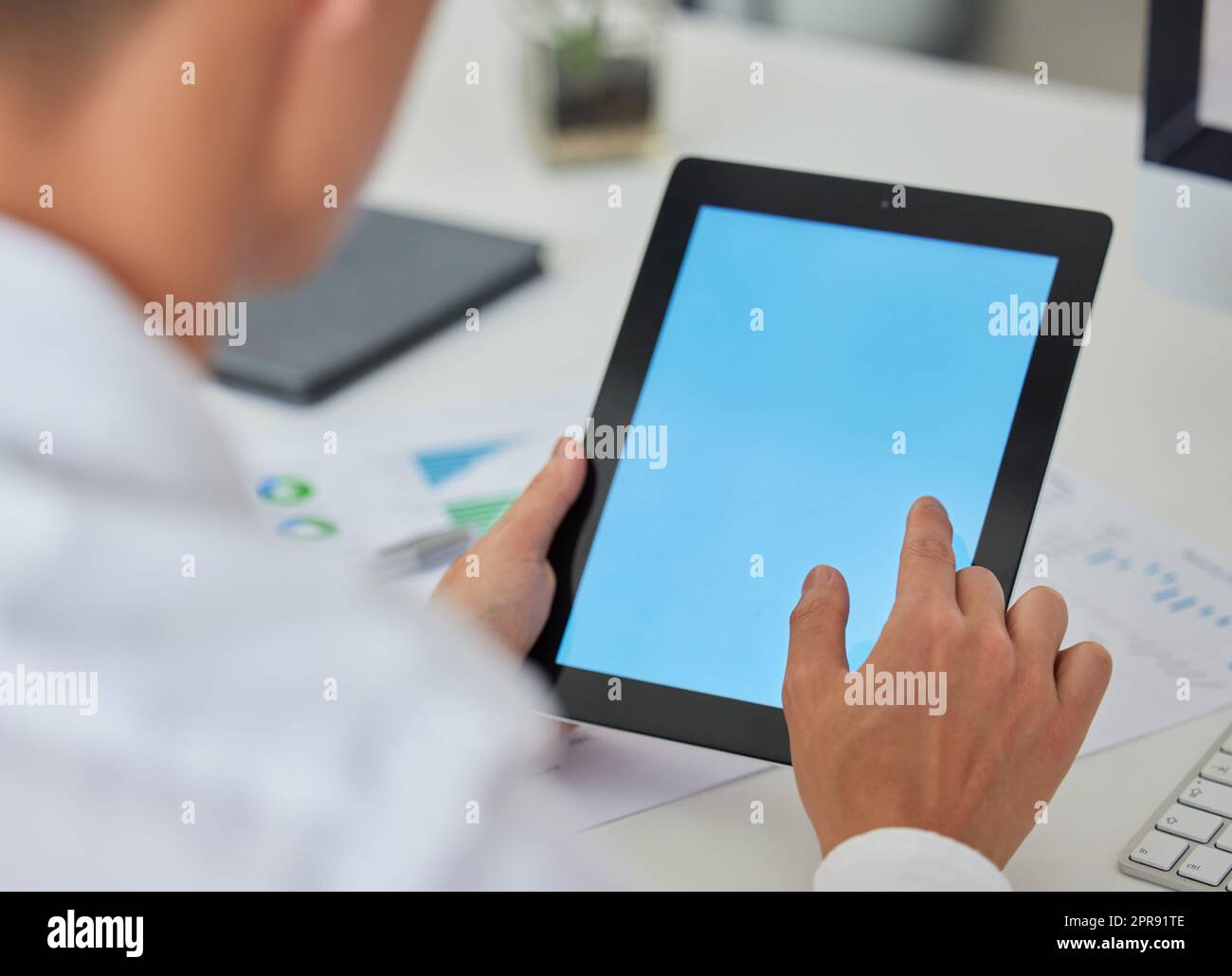 Unknown businessman browsing the internet on an office digital tablet ...