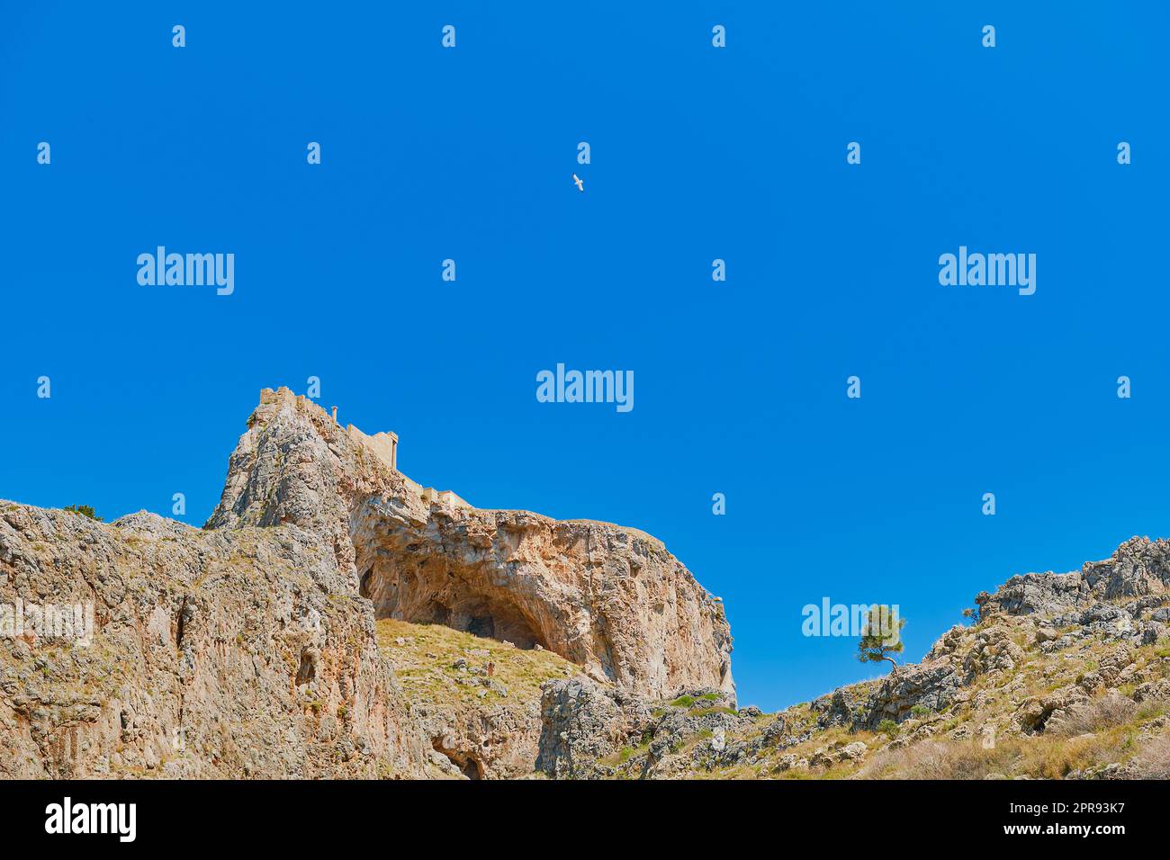 View of the acropolis and caves in the city of Lindos from the bay side ...
