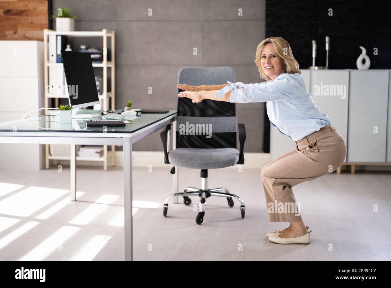 Female Doing Office Yoga Exercise Sit Up And Stretch Stock Photo - Alamy
