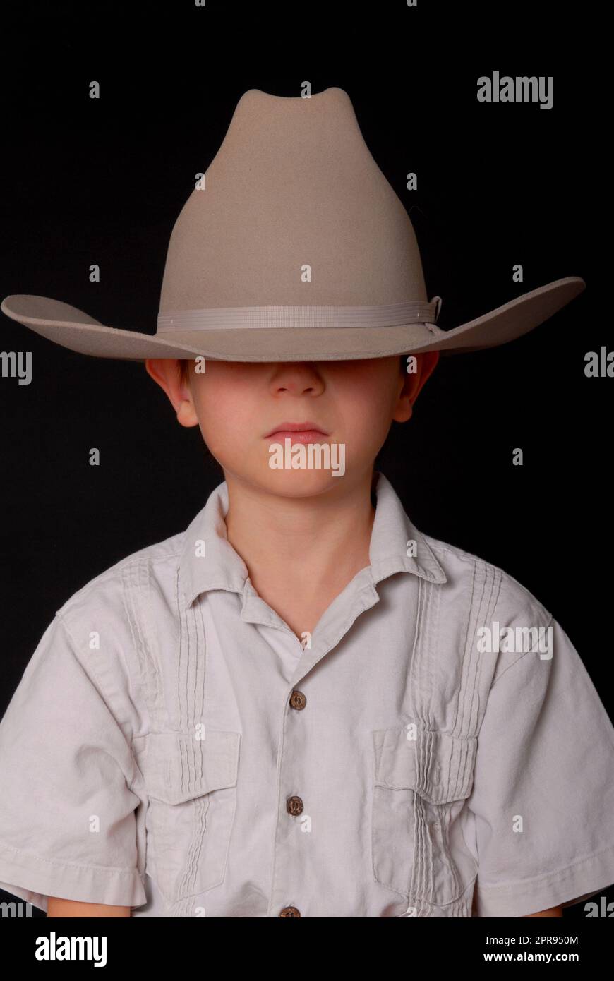 Young boy wearing a cowboy hat isolated on black Stock Photo - Alamy