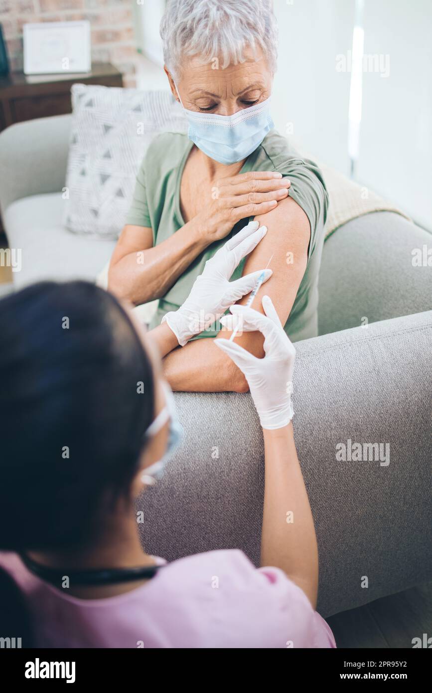 Its easier if you dont move. a doctor giving a masked older woman an ...