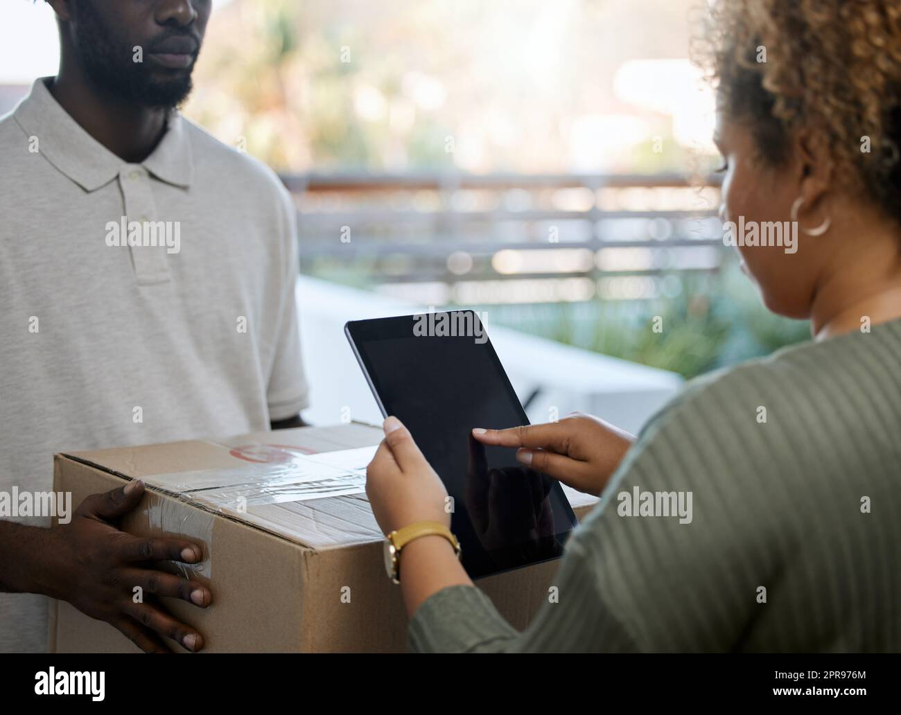 The decor has arrived. a unrecognizable woman receiving a box from a ...