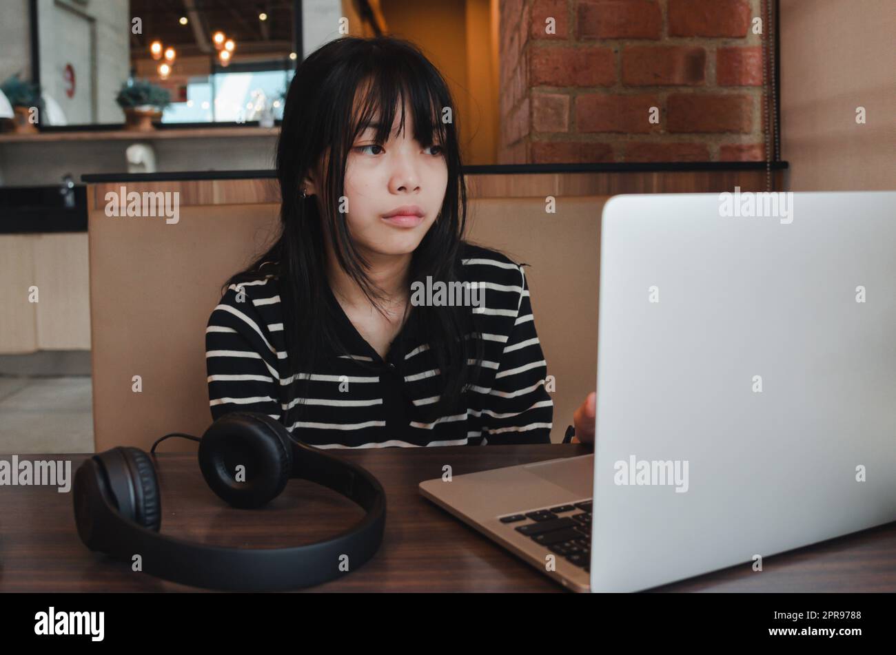 girl using computer laptop watching movie or listen music with earphone ...