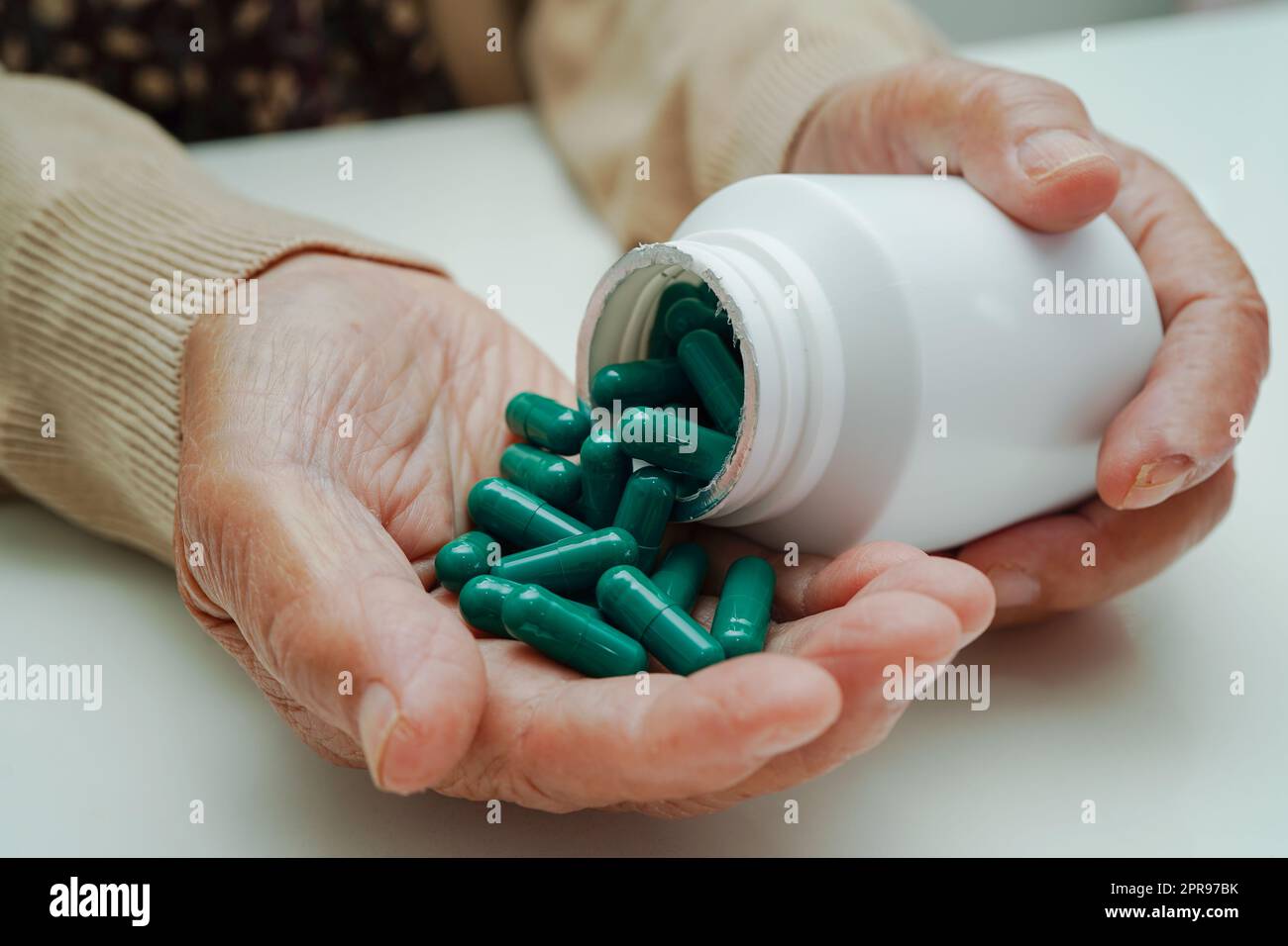 Asian elderly woman holding pill drug in hand, strong healthy medical ...