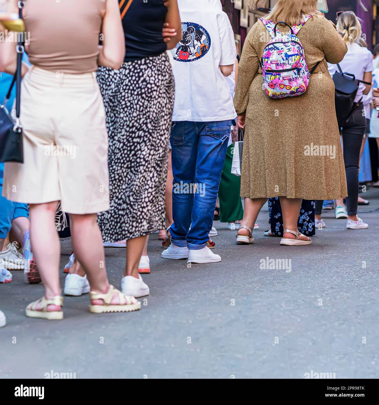 Group of young people standing in queue, rear view, summer day ...