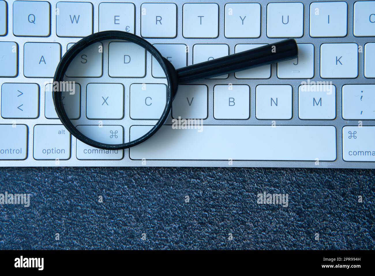 Magnifying glass and keyboard. Discover how to use SEO to improve your ...