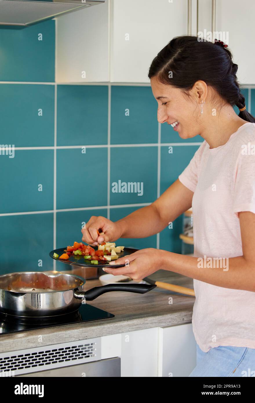 Its easier to add in than to take out. a young woman adding her raw ...