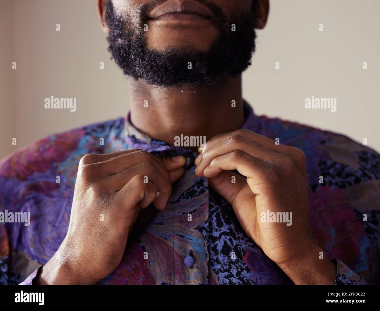 When you look good, you feel good. an unrecognizable man buttoning a ...