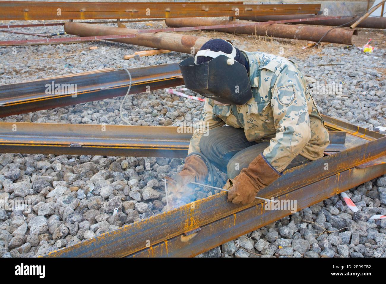 Welder in mask welding metal construction on open air Stock Photo - Alamy