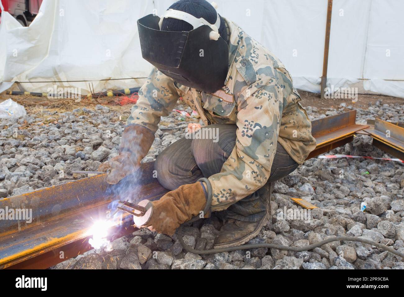 Welder in mask welding metal construction on open air Stock Photo - Alamy