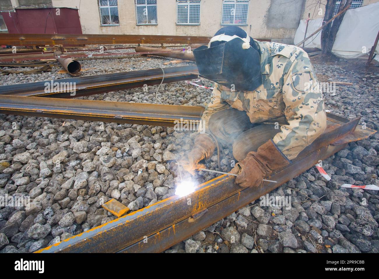 Welder in mask welding metal construction on open air Stock Photo - Alamy