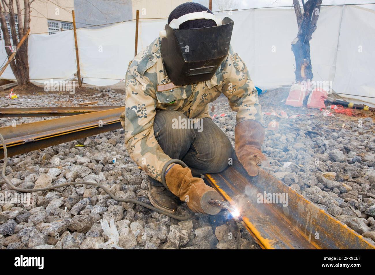 Welder in mask welding metal construction on open air Stock Photo - Alamy