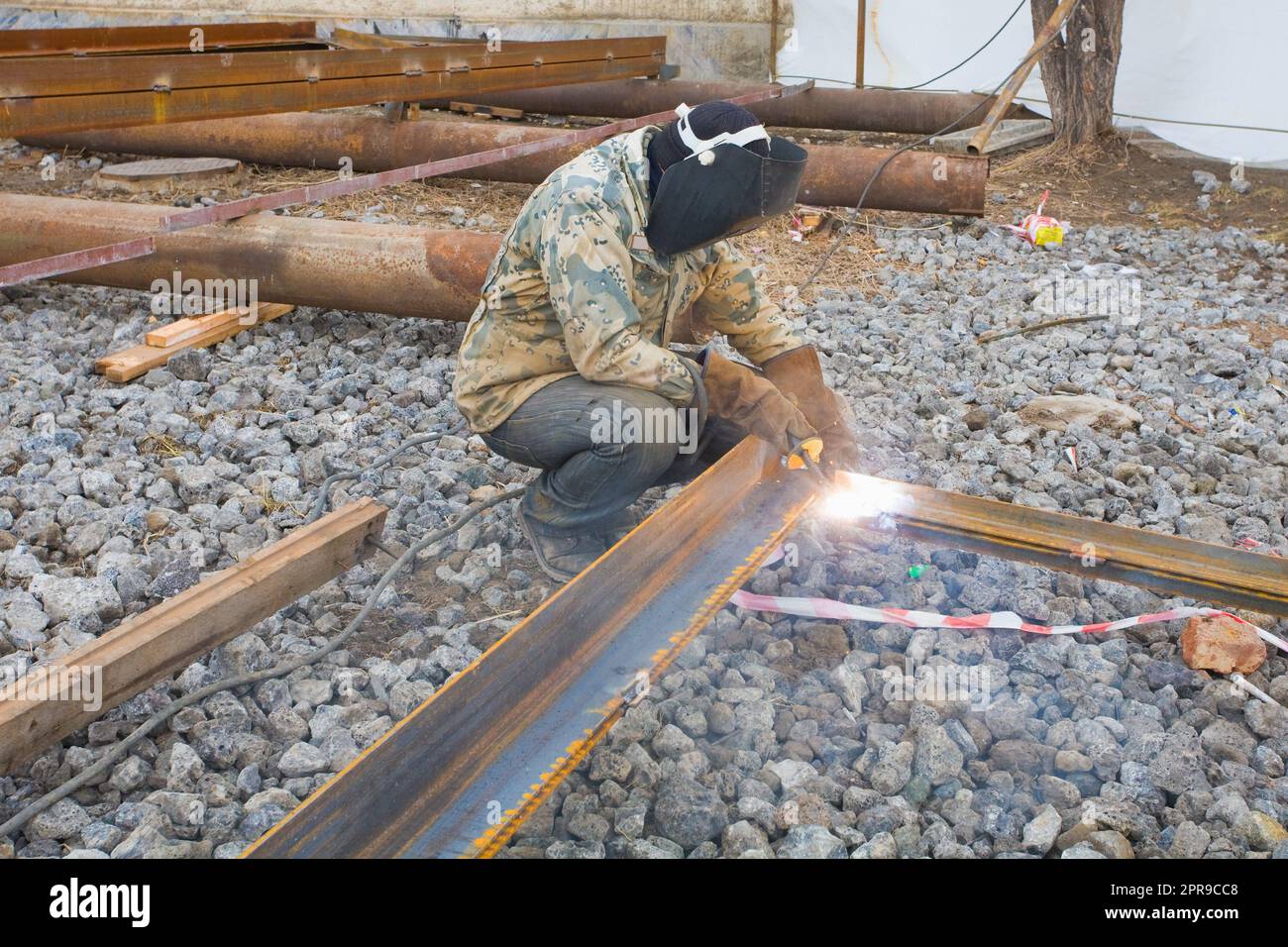 Welder in mask welding metal construction on open air Stock Photo - Alamy