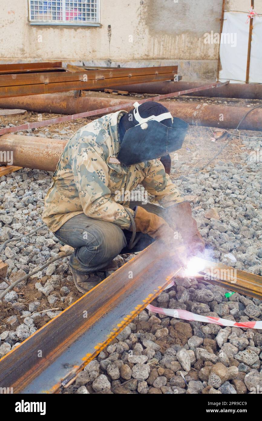 Welder in mask welding metal construction on open air Stock Photo - Alamy