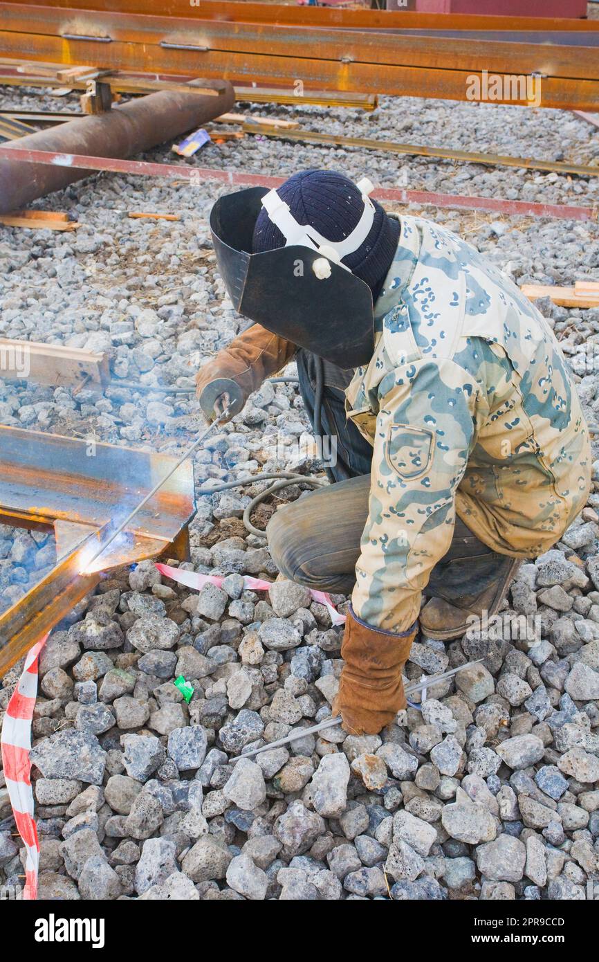 Welder in mask welding metal construction on open air Stock Photo - Alamy