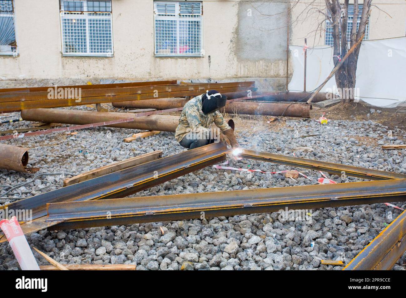 Welder in mask welding metal construction on open air Stock Photo - Alamy