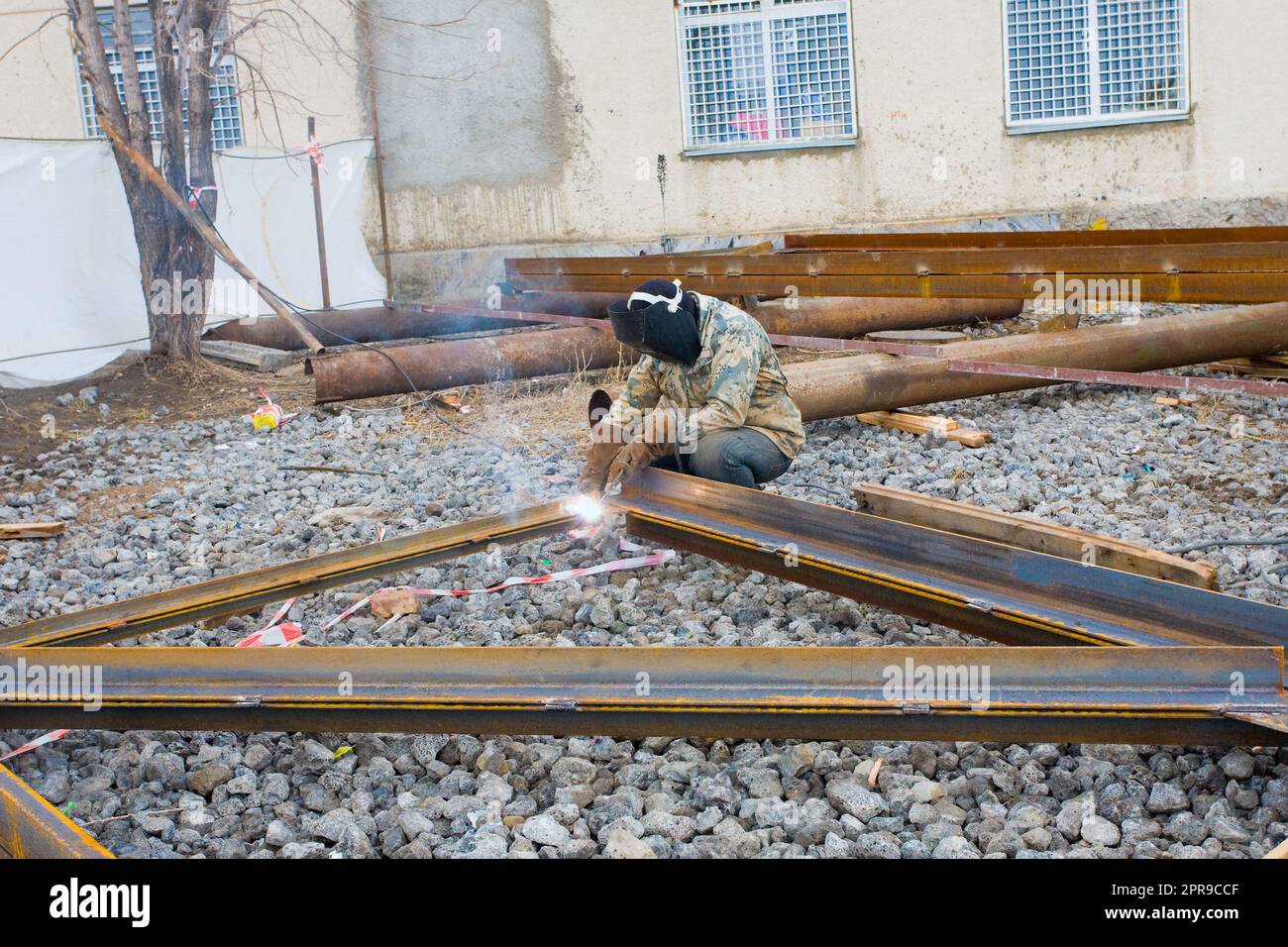 Welder in mask welding metal construction on open air Stock Photo - Alamy