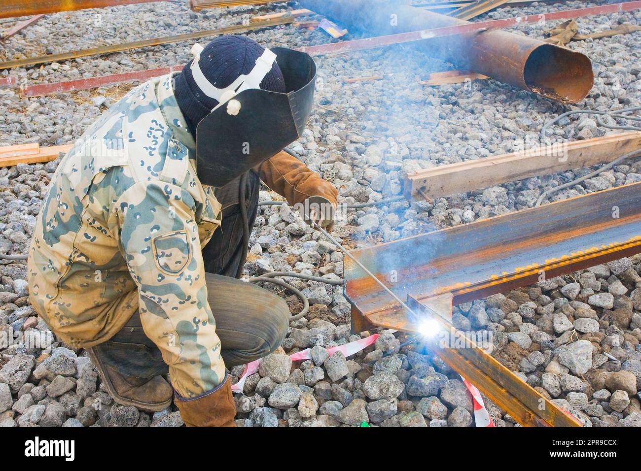 Welder in mask welding metal construction on open air Stock Photo - Alamy