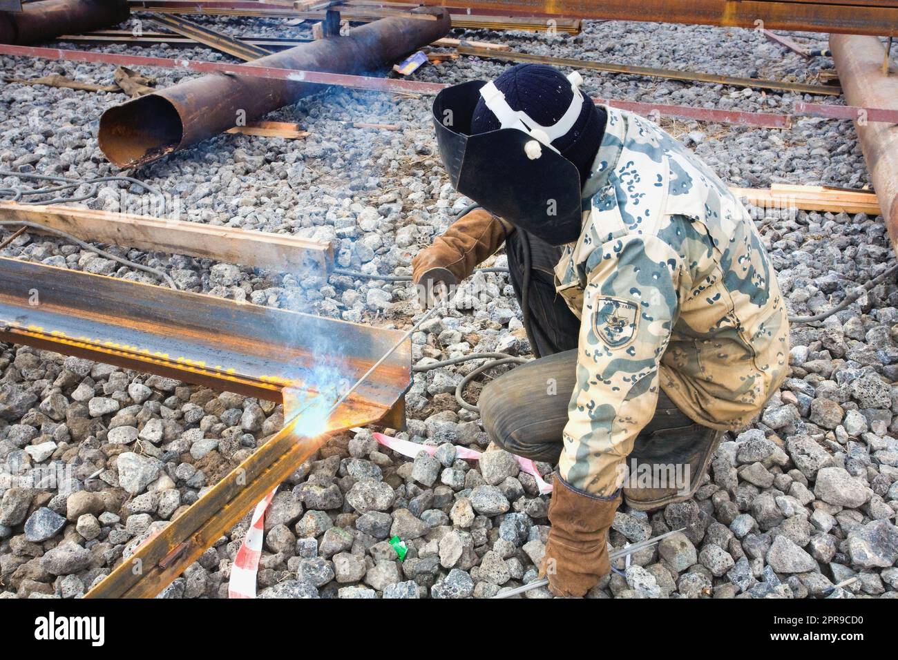 Welder in mask welding metal construction on open air Stock Photo - Alamy