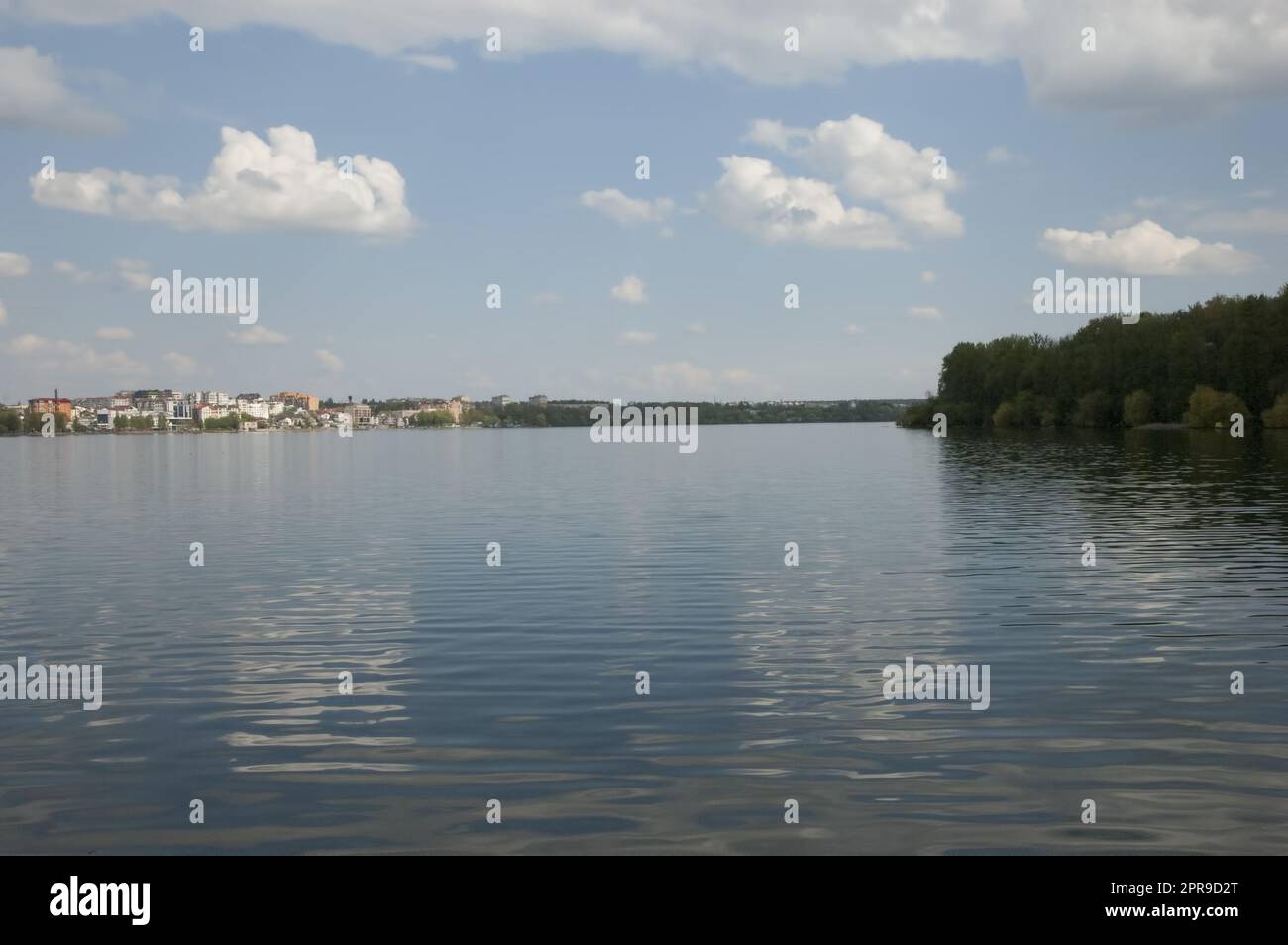The blue sky with white clouds is reflected in the water with fine ...