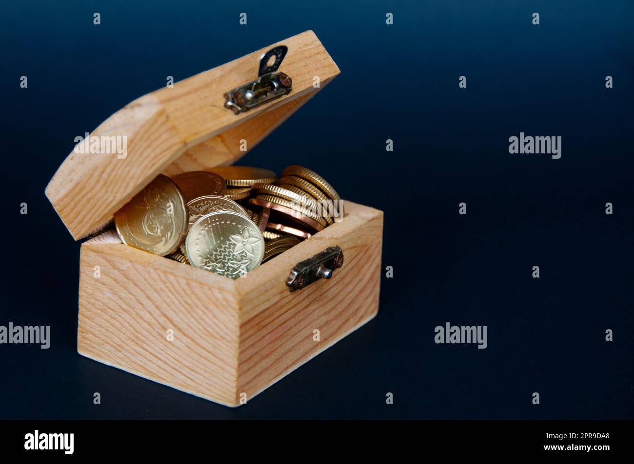 Gold coins inside treasure chest on dark background cover. Copy space ...