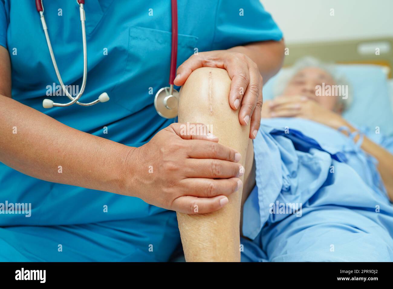Doctor checking Asian elderly woman patient with scar knee replacement ...