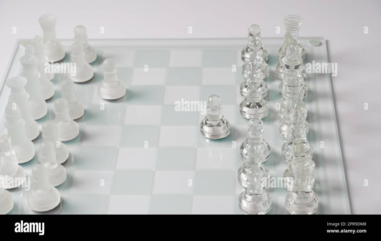 Transparent chess figures on reflective chess board. Pawns forward one ...
