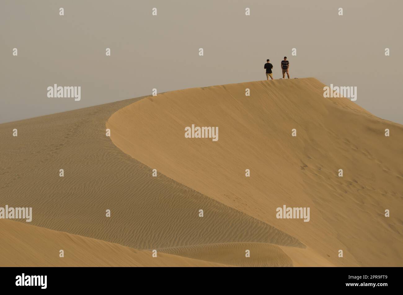 Two men in a sand dune Stock Photo - Alamy