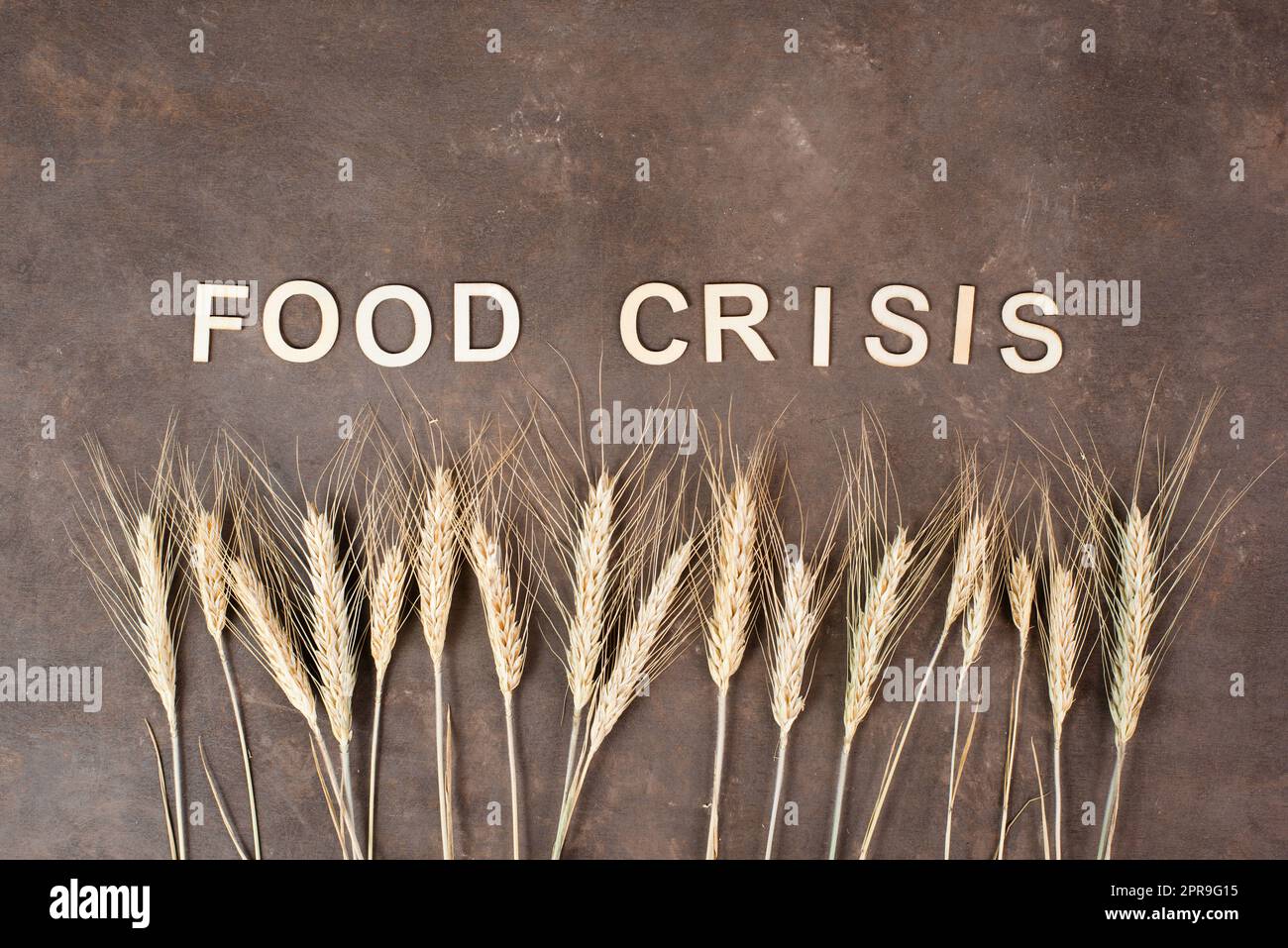 Food crisis with increasing prices and shortages, wheat ears on a brown ...